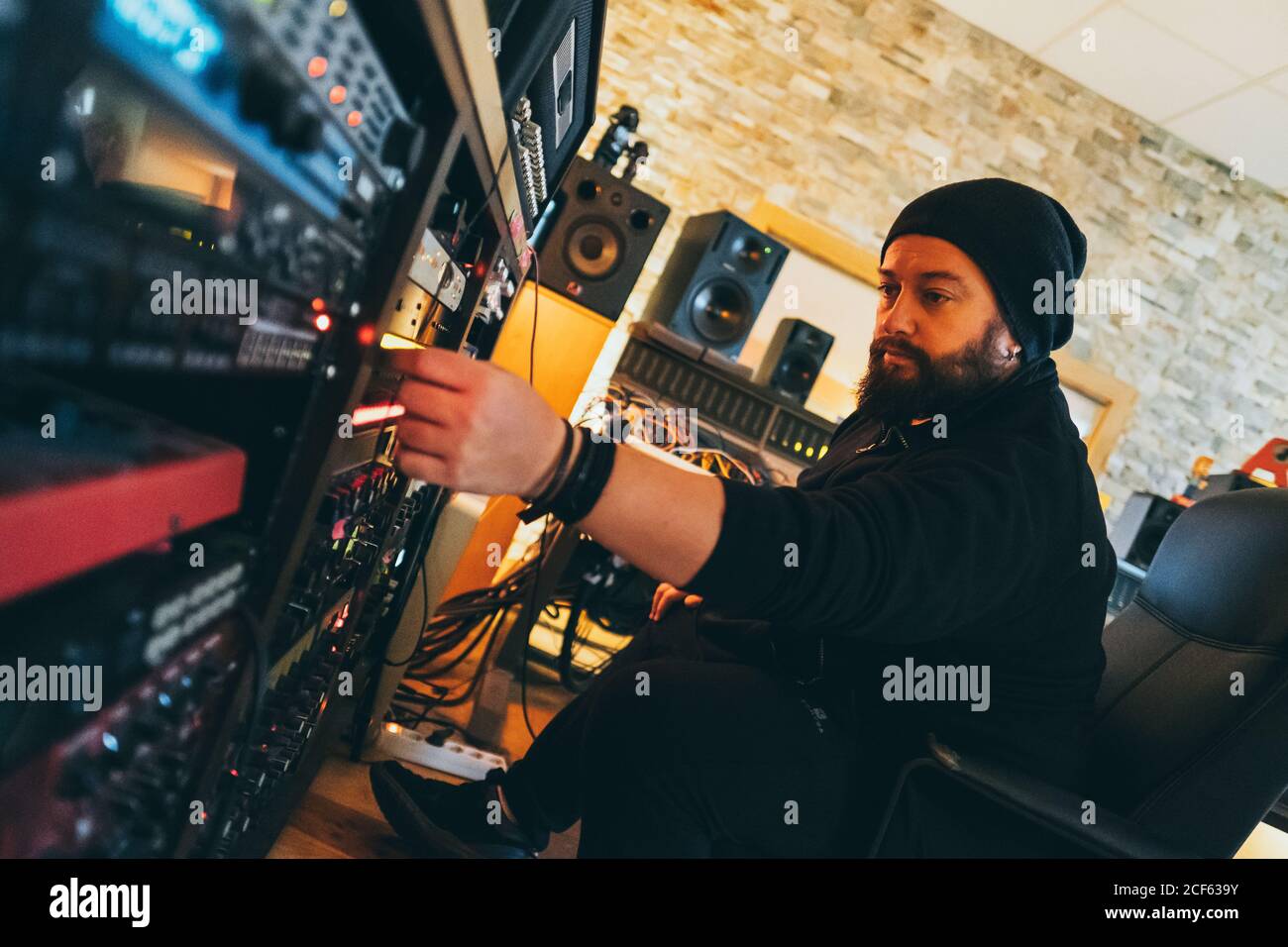 man musician working while adjusting music stereo control in a studio ...