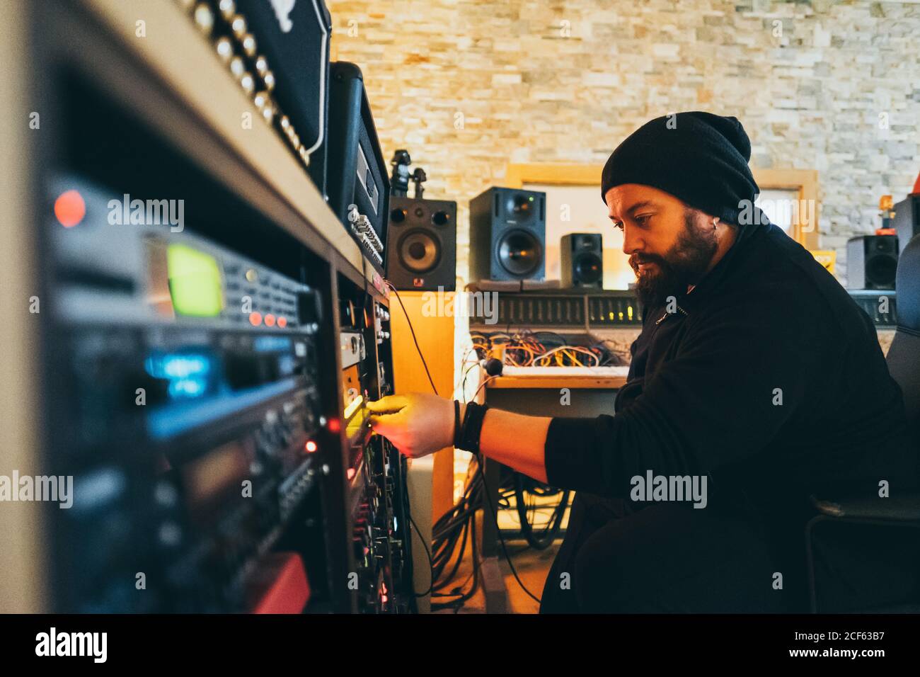 man musician working while adjusting music stereo control in a studio ...