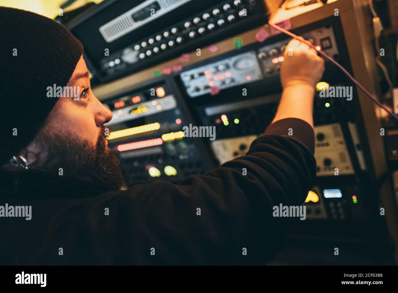 man musician working while adjusting music stereo control in a studio ...
