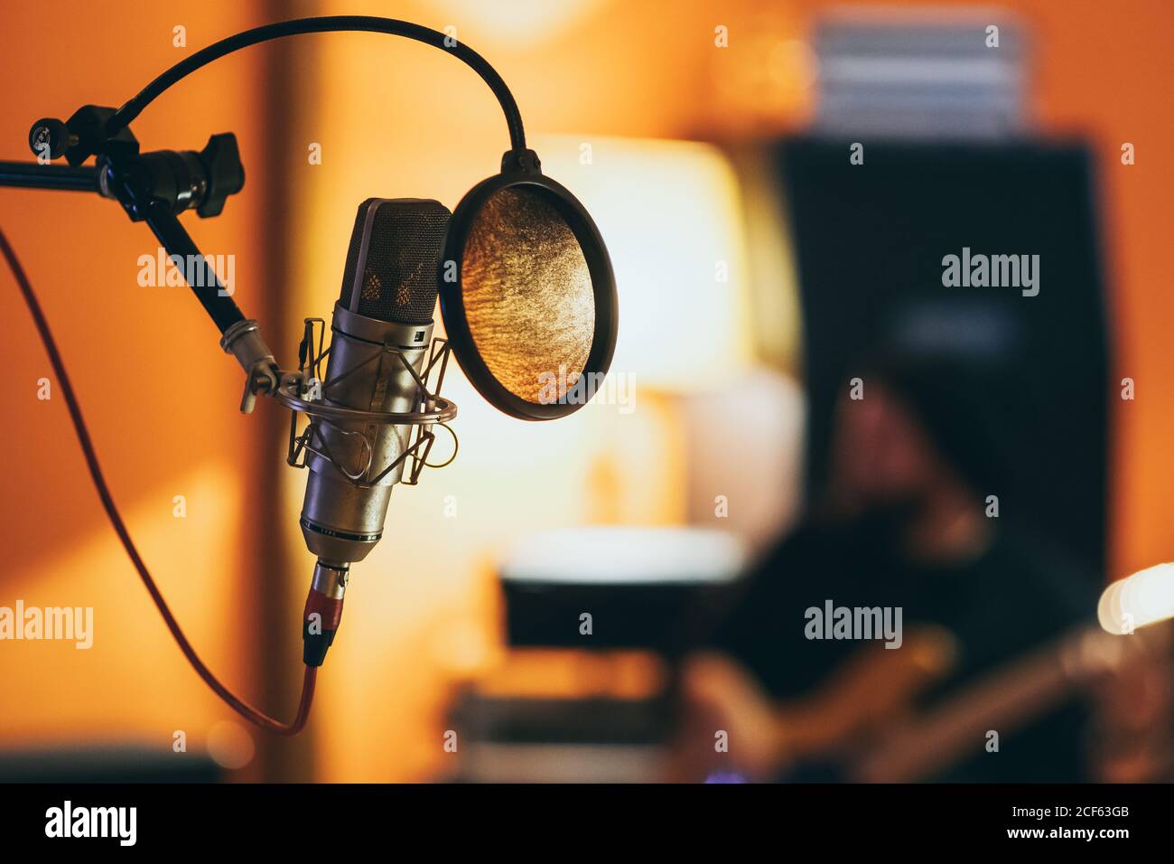 Professional microphone in studio with cable hanging Stock Photo - Alamy