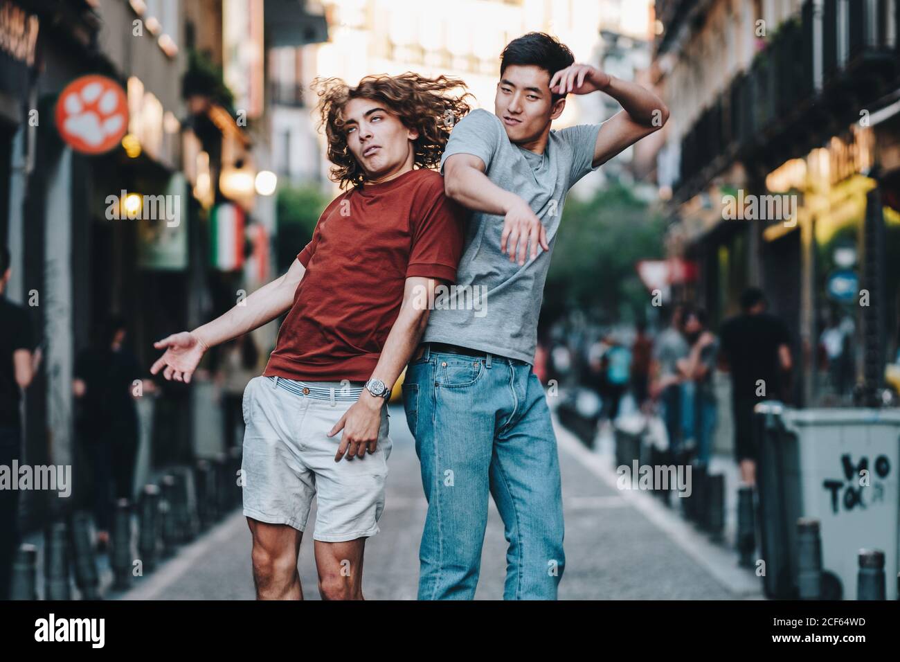 Side view of excited multiracial men jumping together and slamming back ...