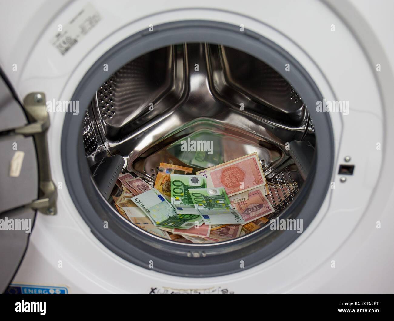 A pile of dirty money in a clothes machine. washing steam in the drum ...