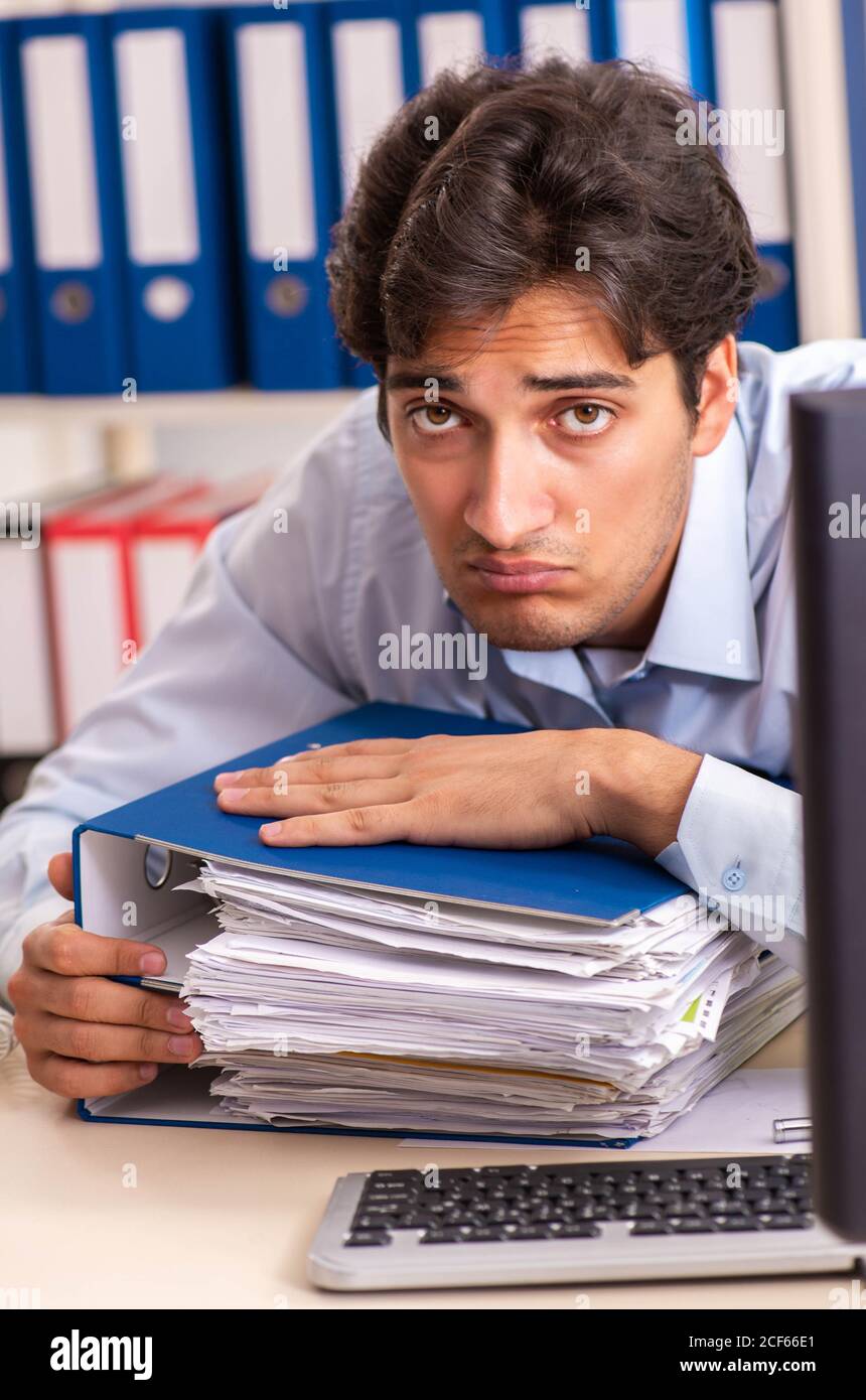 The overloaded busy employee with too much work and paperwork Stock ...