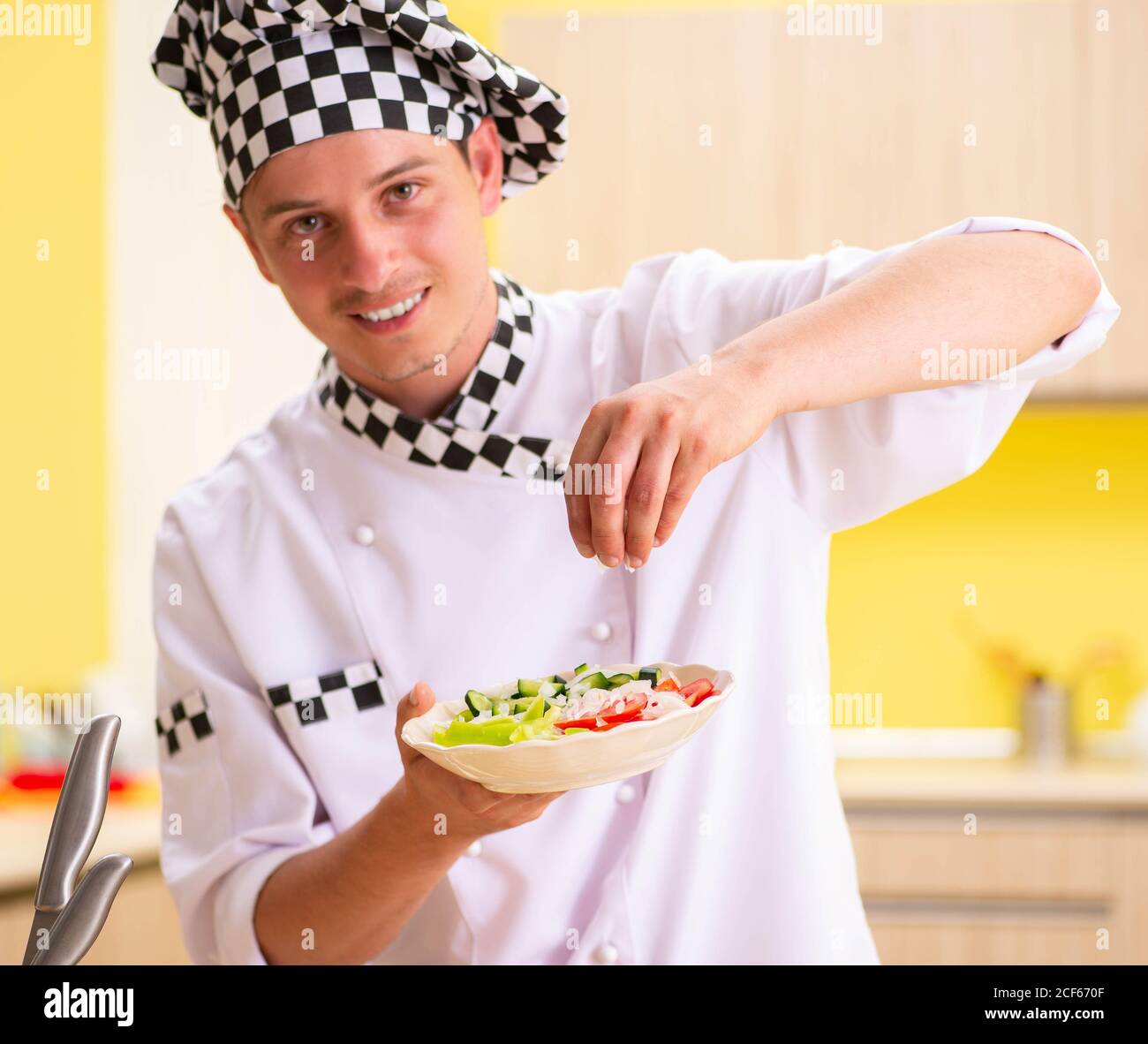 The young professional cook preparing salad at kitchen Stock Photo - Alamy