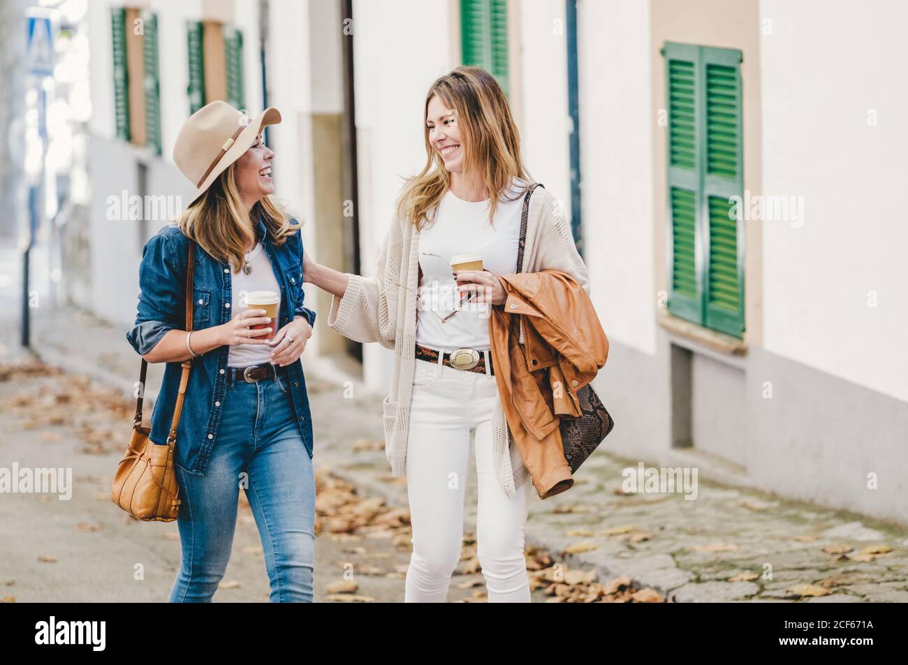 Stylish relaxed Woman chatting happily while walking down street having ...
