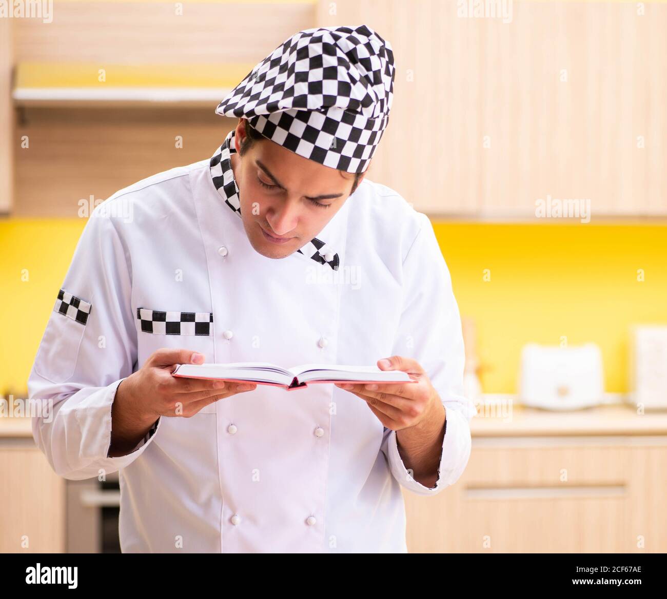 The young professional cook preparing in kitchen Stock Photo - Alamy