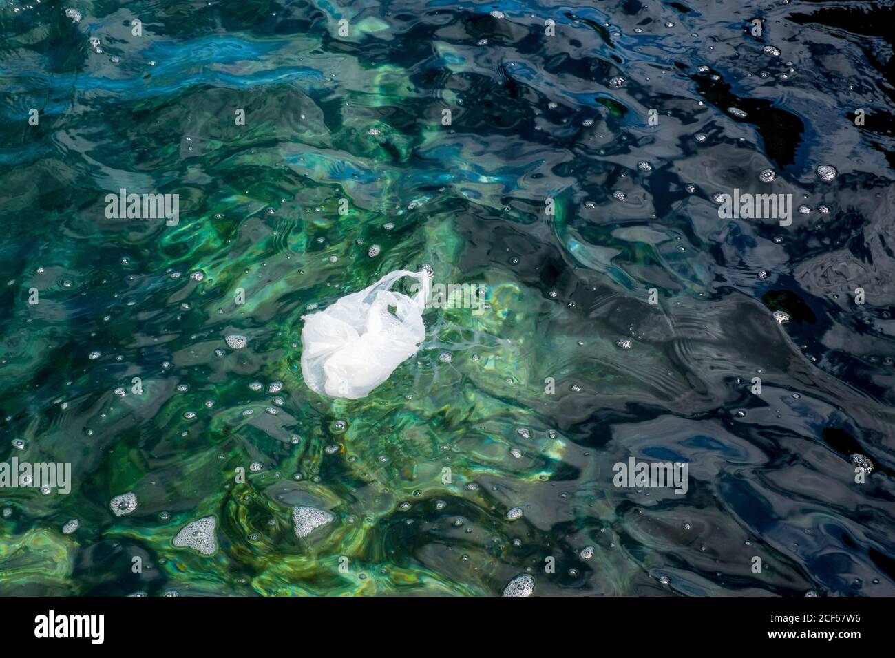 From above plastic bag floating in water polluting environment Stock ...
