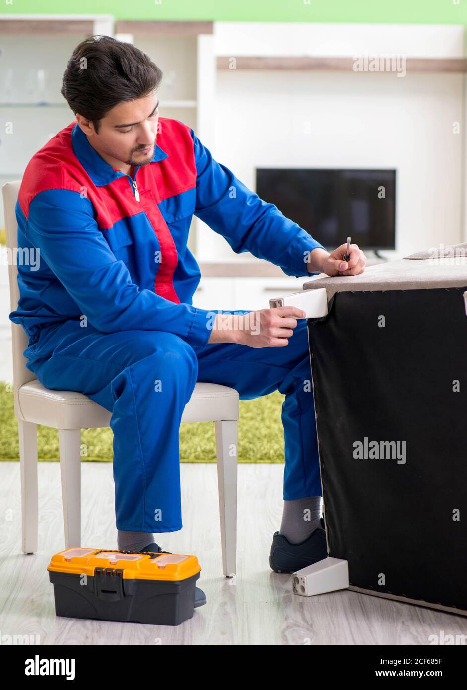 The repair contractor repairing broken furniture at home Stock Photo ...
