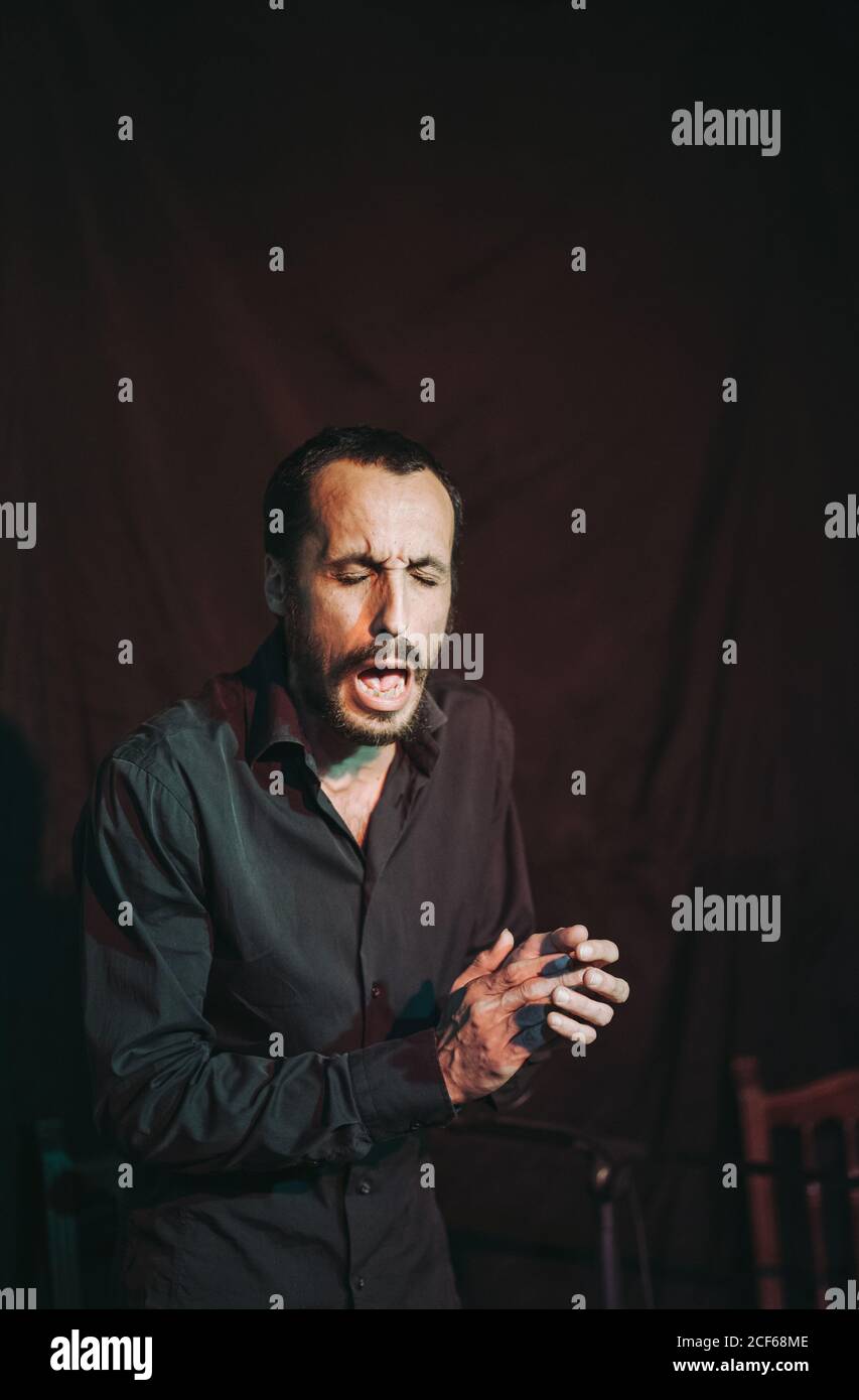 Adult Hispanic musician clapping while singing flamenco song on stage ...