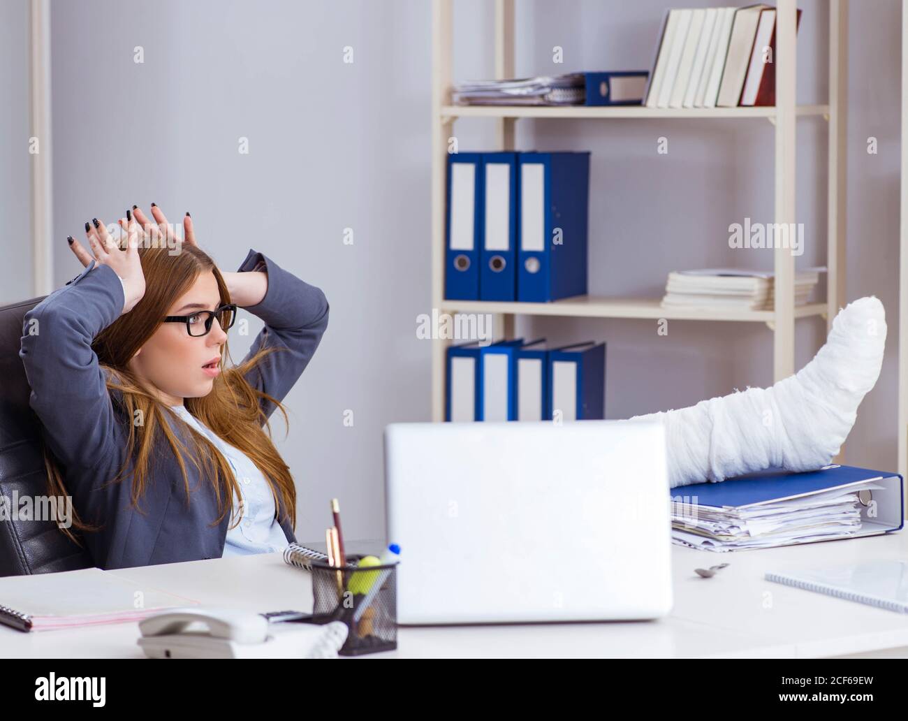 The busiesswoman employee with broken leg in office Stock Photo - Alamy