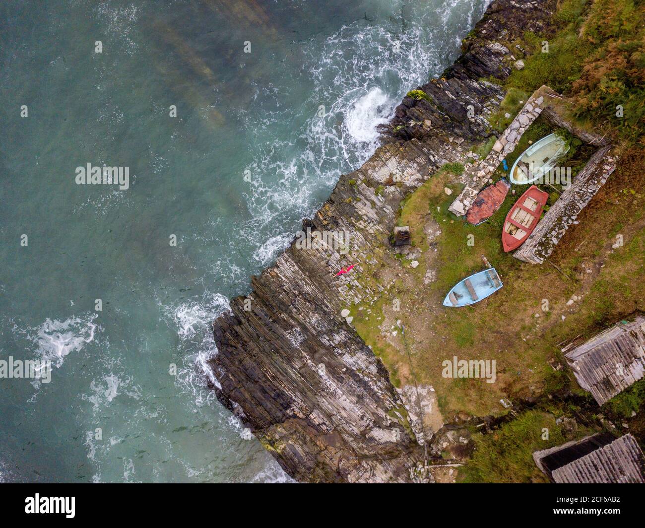 Boats on small part of seashore washing by foamy waves Stock Photo - Alamy
