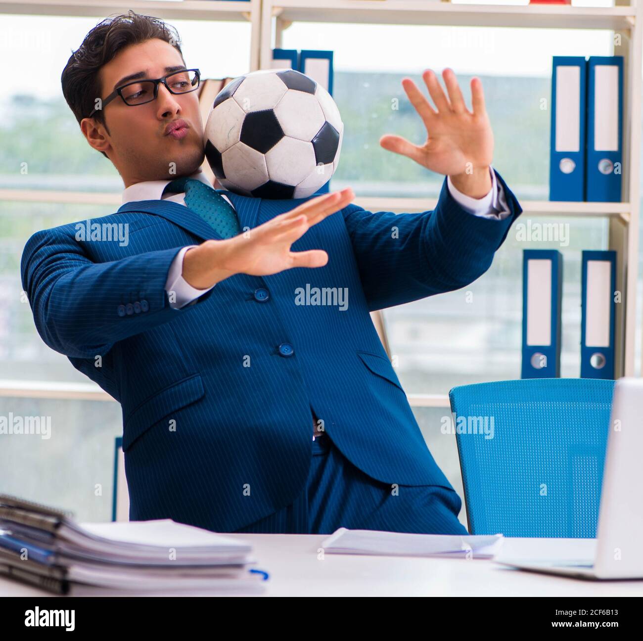 The businessman playing football in the office Stock Photo - Alamy