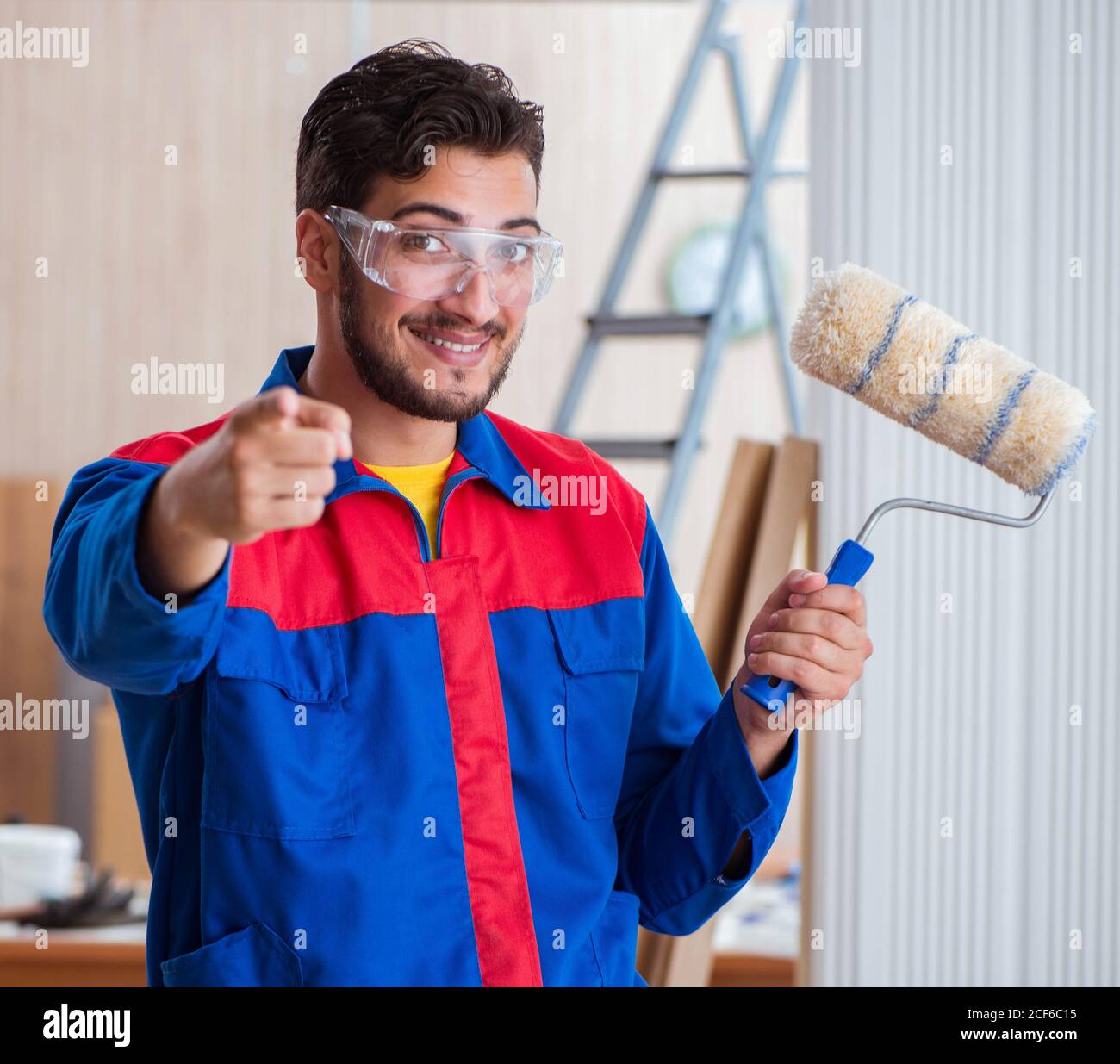 Yooung repairman carpenter working with paint painting Stock Photo - Alamy