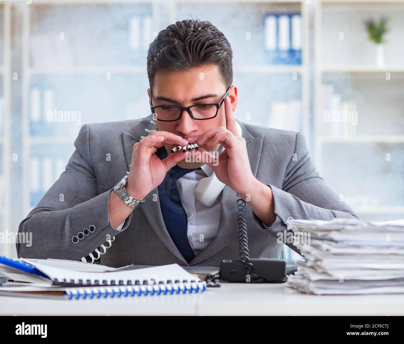 The businessman smoking in office at work Stock Photo - Alamy
