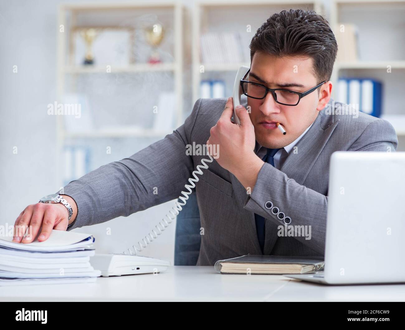The businessman smoking in office at work Stock Photo - Alamy