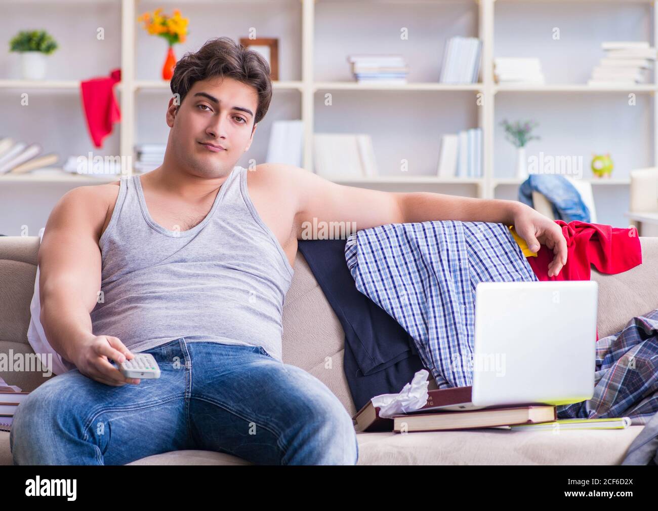 Young man working studying in messy room Stock Photo - Alamy