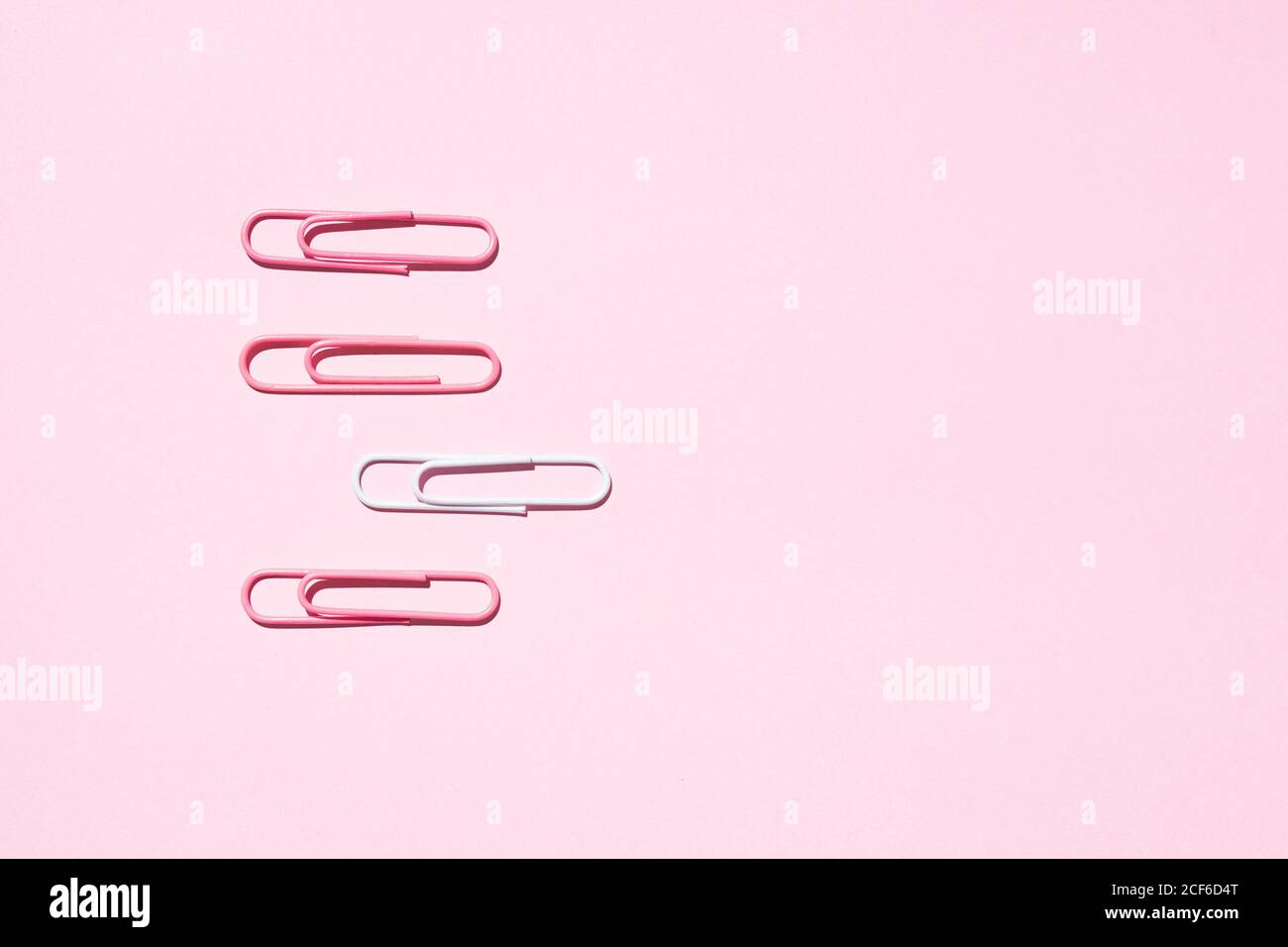 Top view of white and pink paper clips arranged on colorful background ...