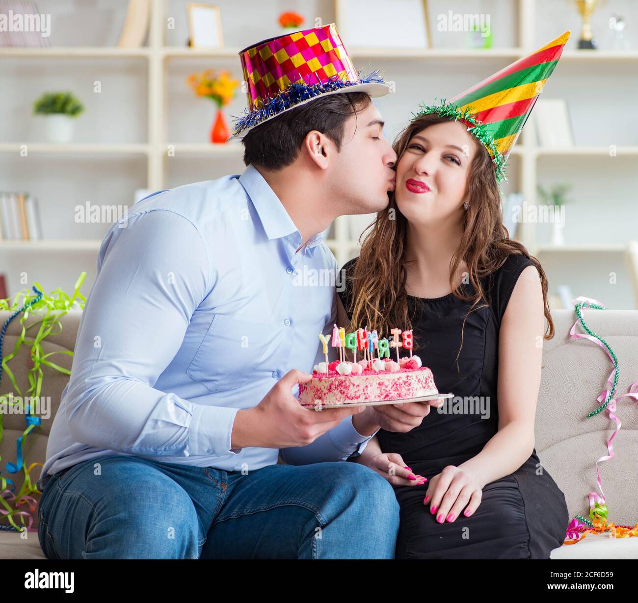 The young couple celebrating birthday with cake Stock Photo - Alamy