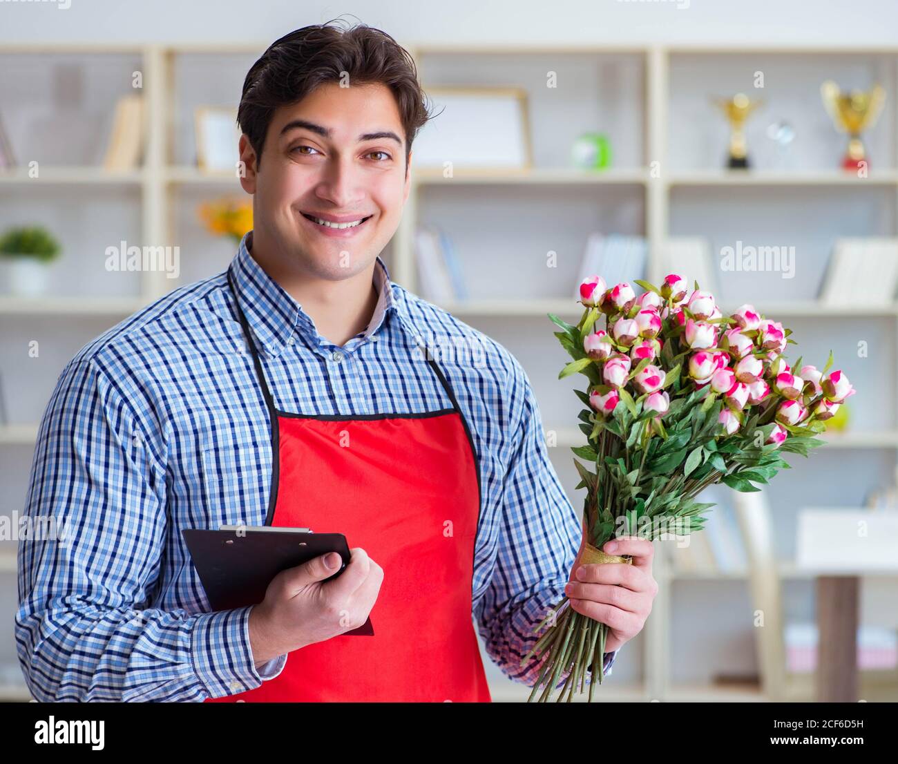 The flower shop assistant offering a bunch of flowers Stock Photo - Alamy