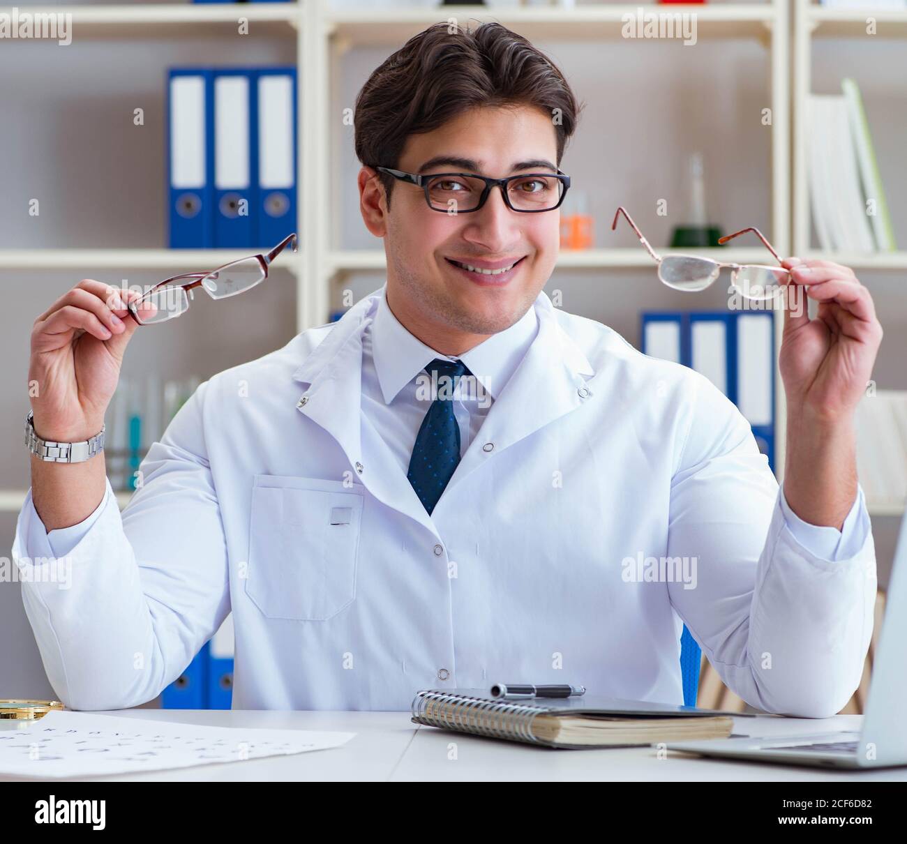 Doctor optician prescribing holding optical glasses Stock Photo - Alamy