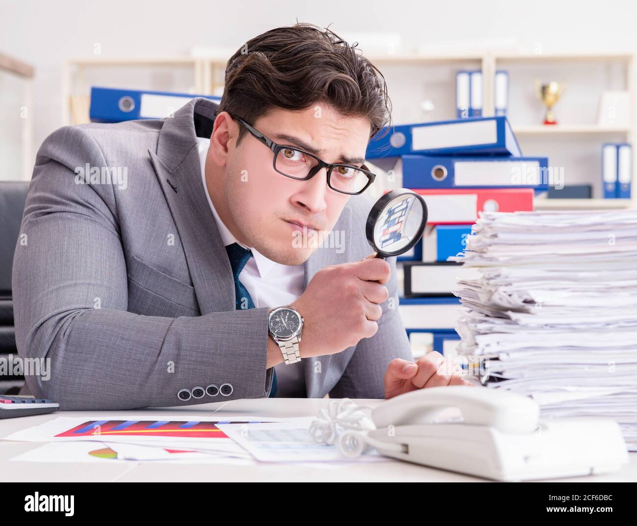 The male businessman with magnifying glass in office Stock Photo - Alamy