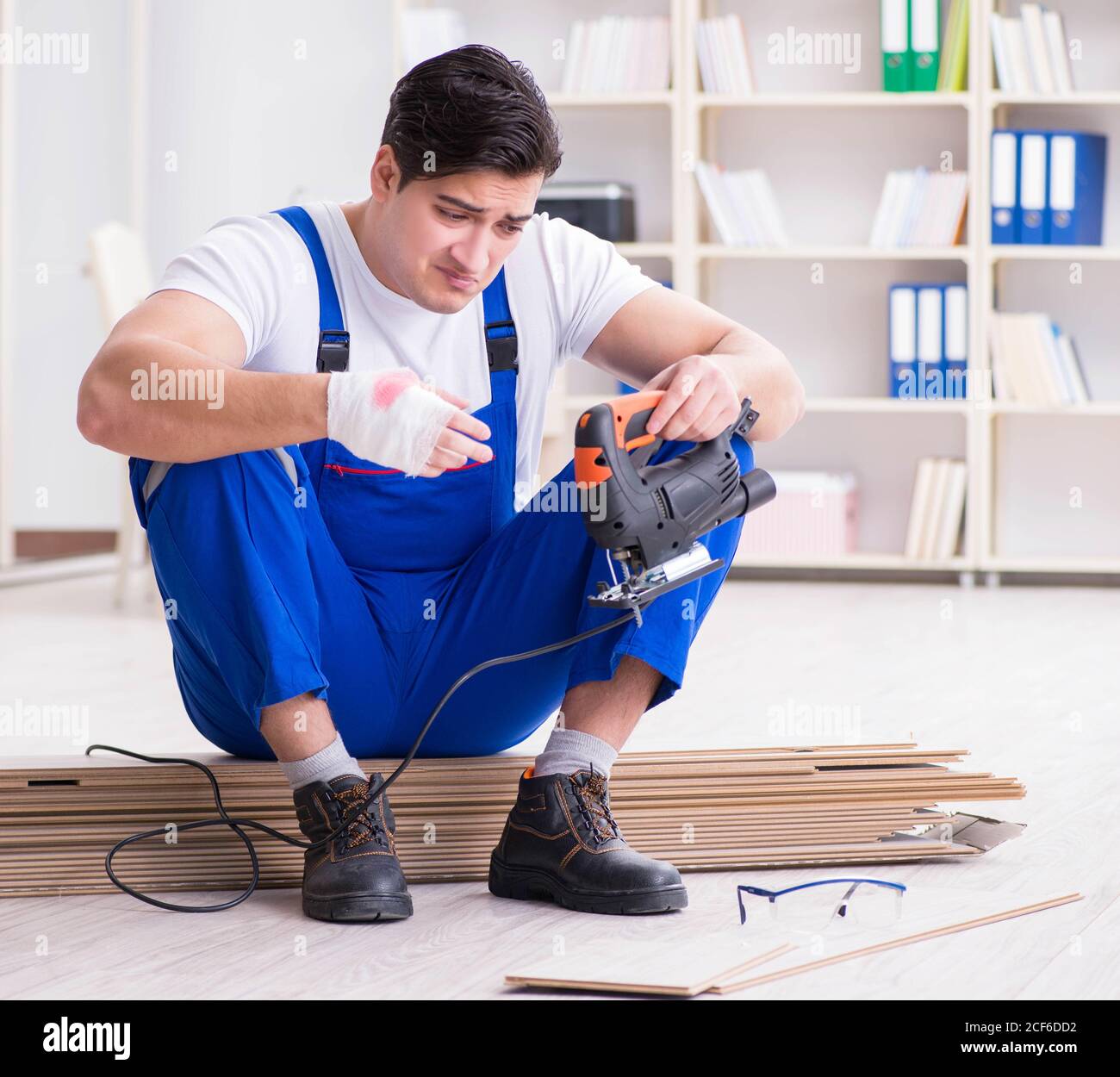 The young worker working on floor laminate tiles Stock Photo - Alamy