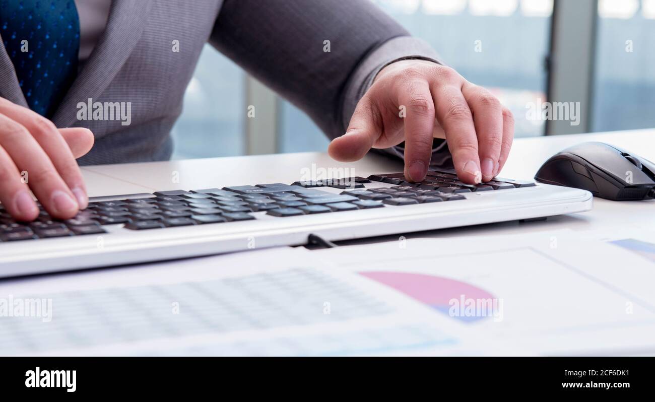 The finance professional working on keyboard with reports Stock Photo ...