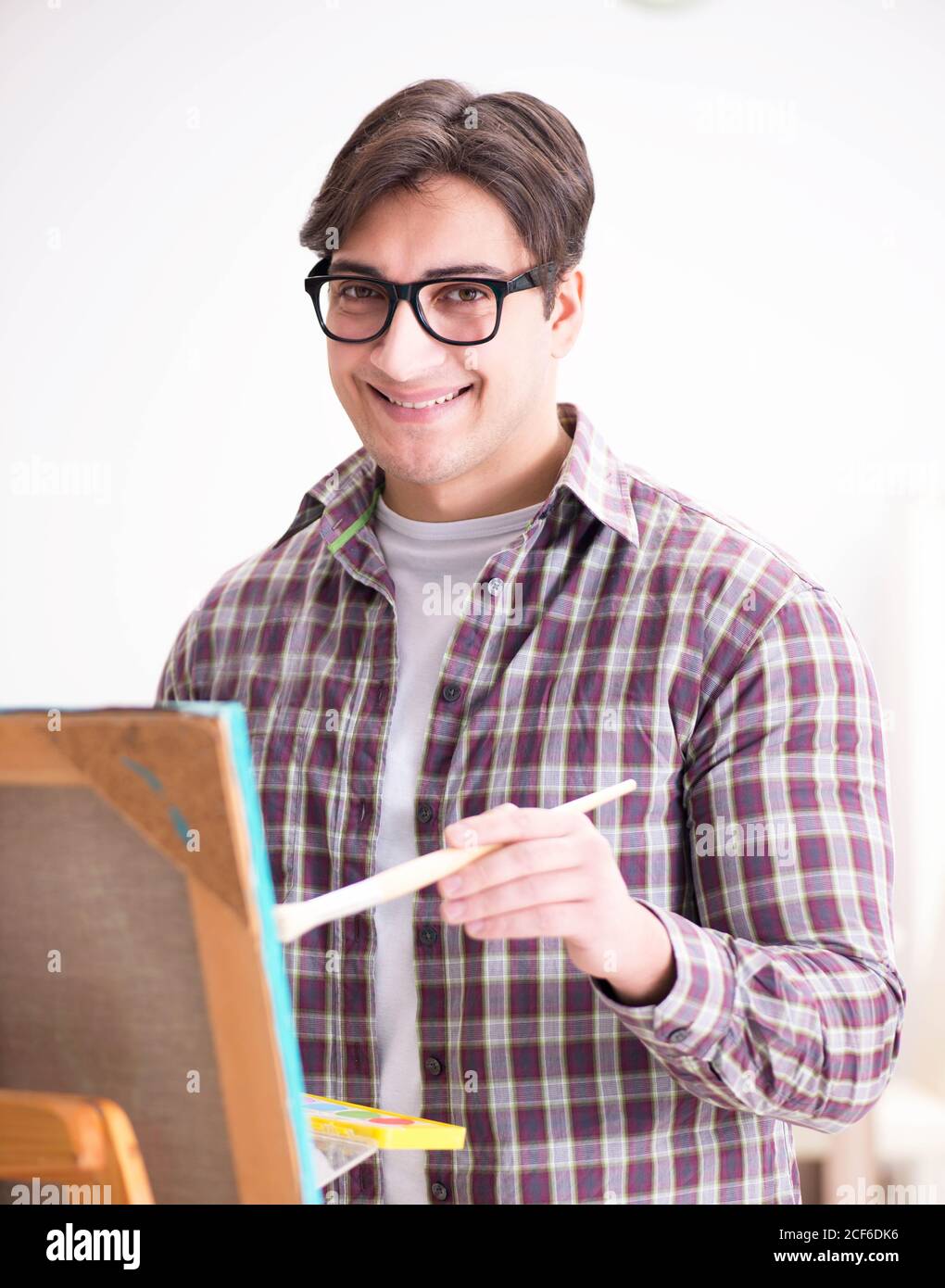 Young male artist drawing pictures in bright studio Stock Photo - Alamy