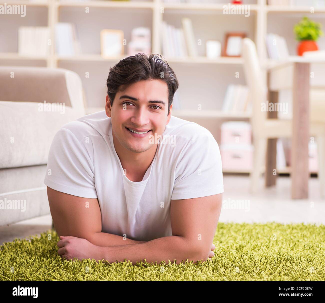 The young happy handsome man on carpet floor Stock Photo - Alamy