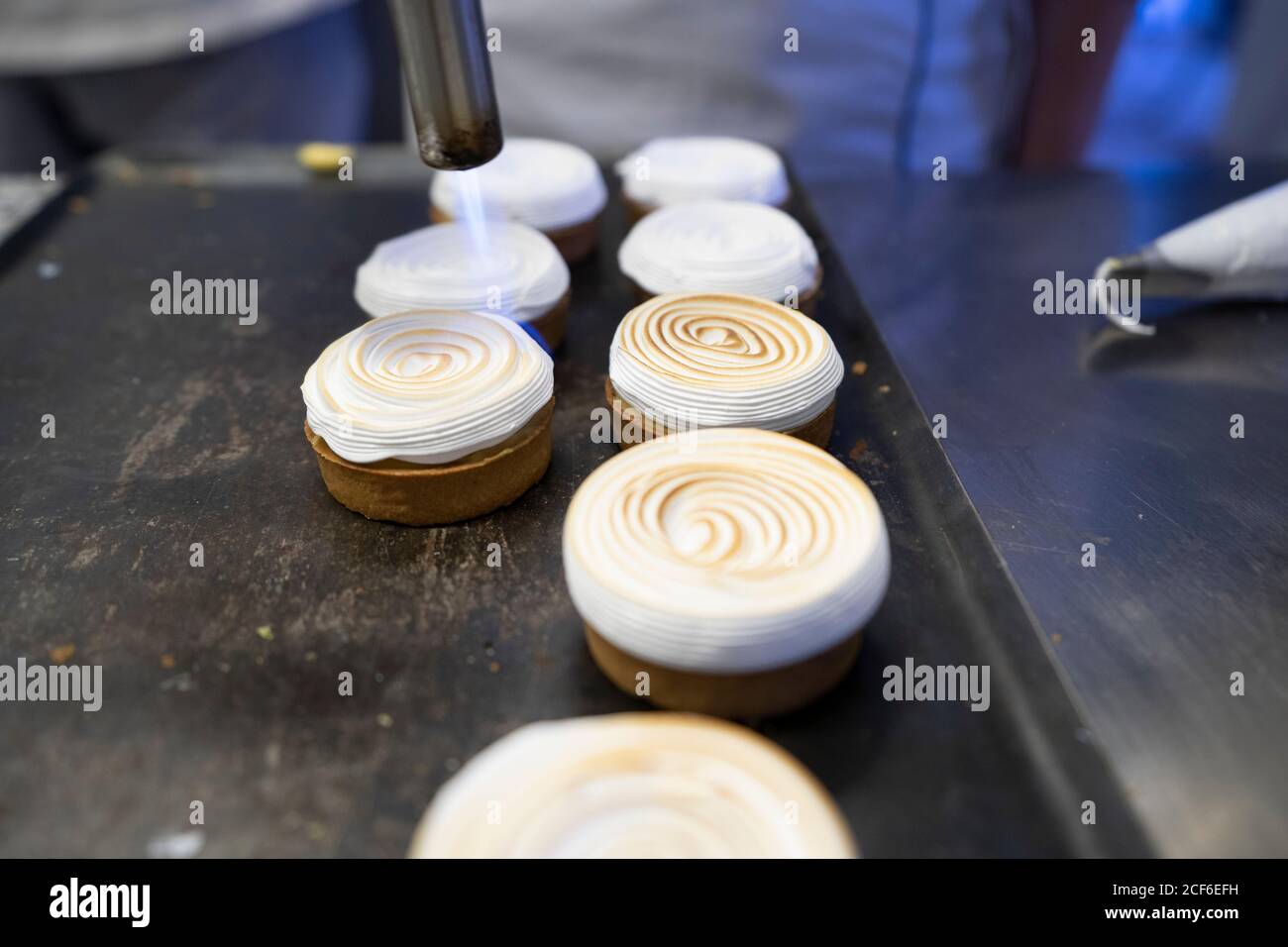 From above cooking delicious round cakes topped with whipped cream ...