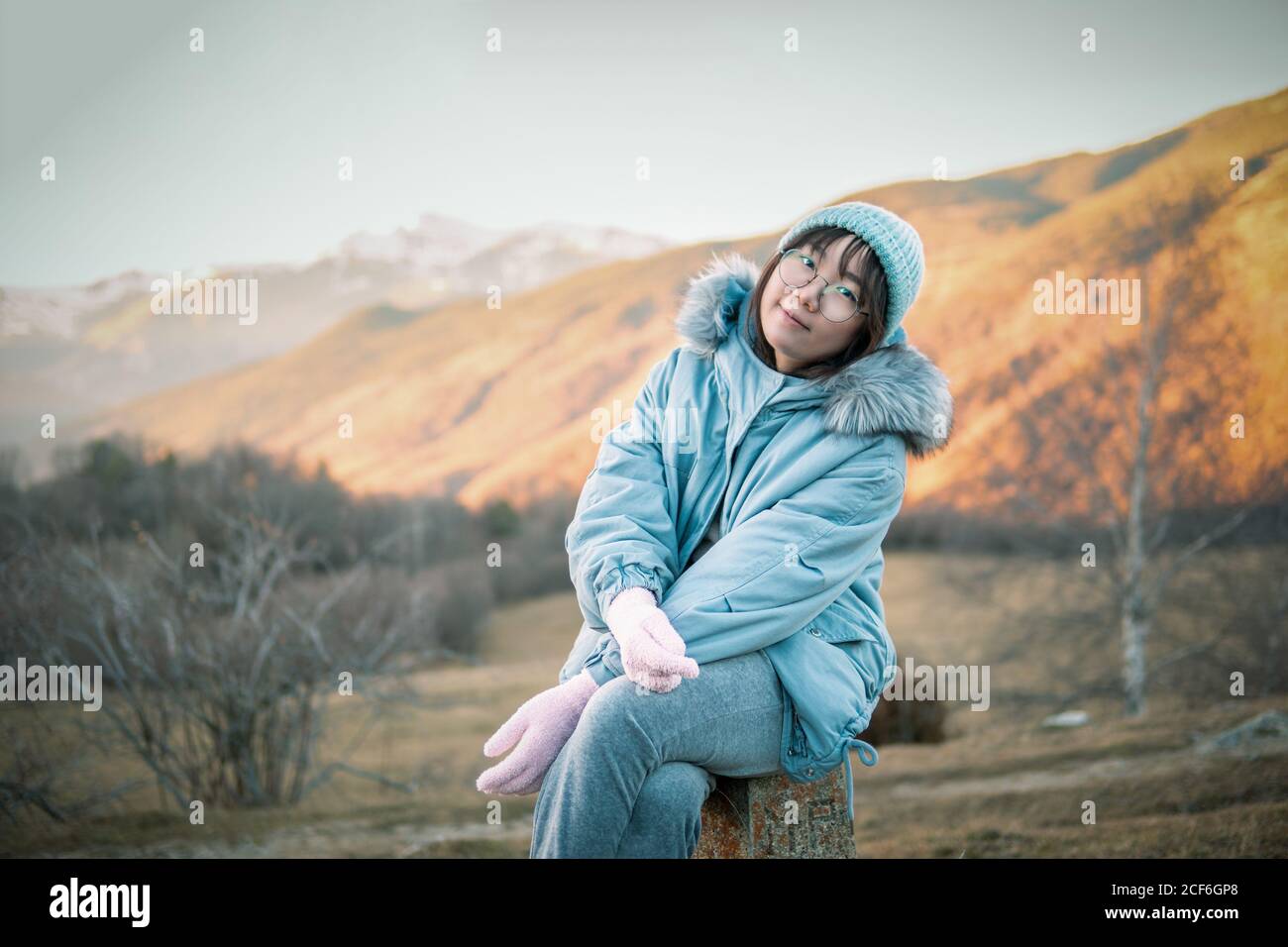 Asian Woman sitting resting in nature contemplating beautiful mountain ...