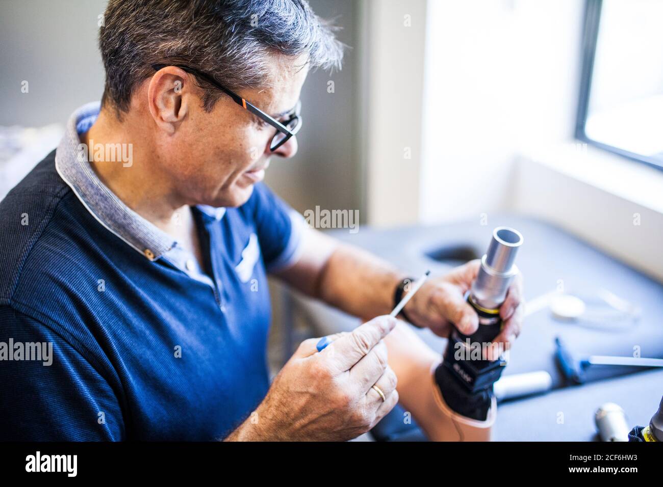 Prosthetic engineer reviewing the prosthesis of a patient and improving ...