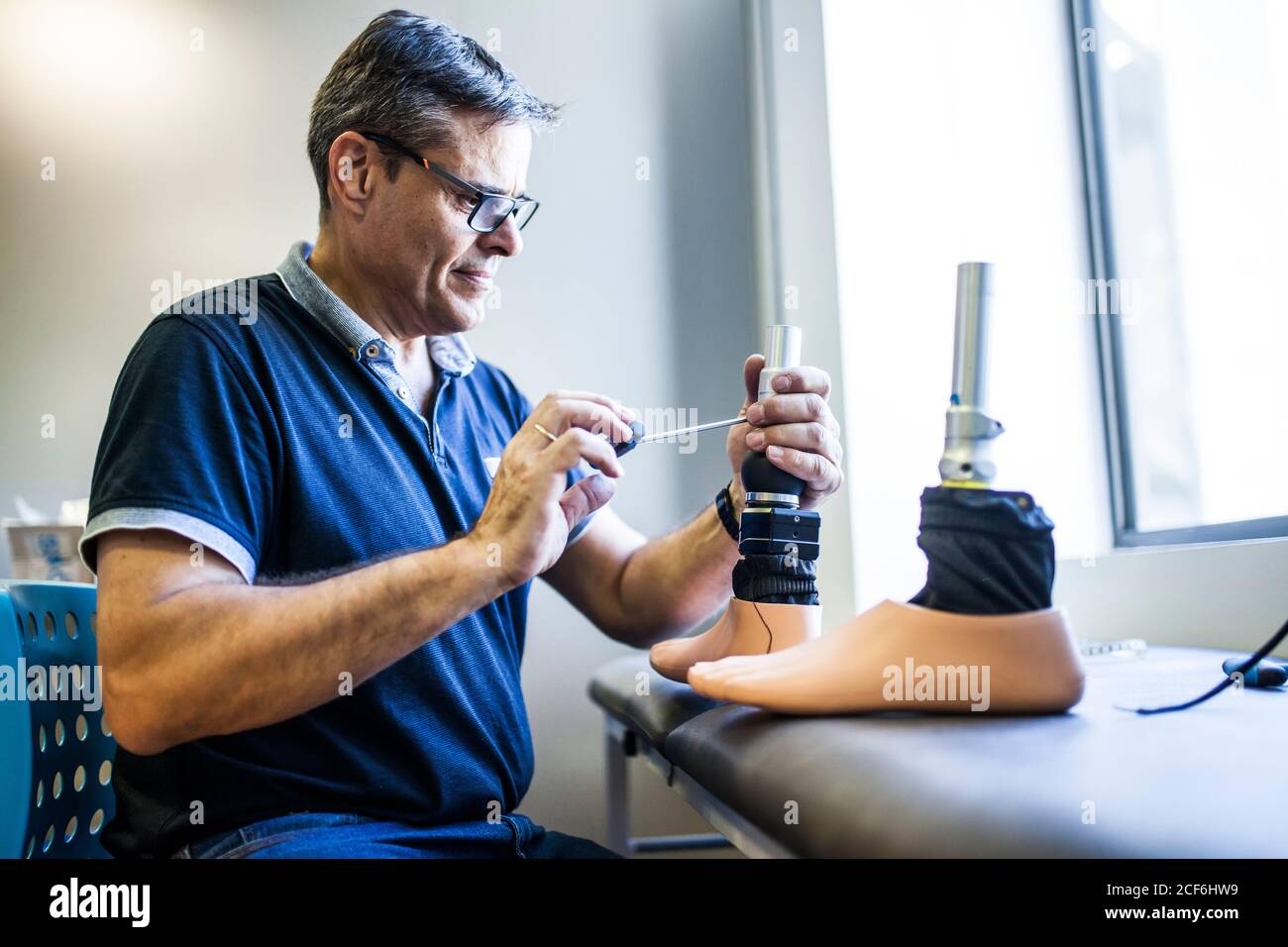 Prosthetic engineer reviewing the prosthesis of a patient and improving ...
