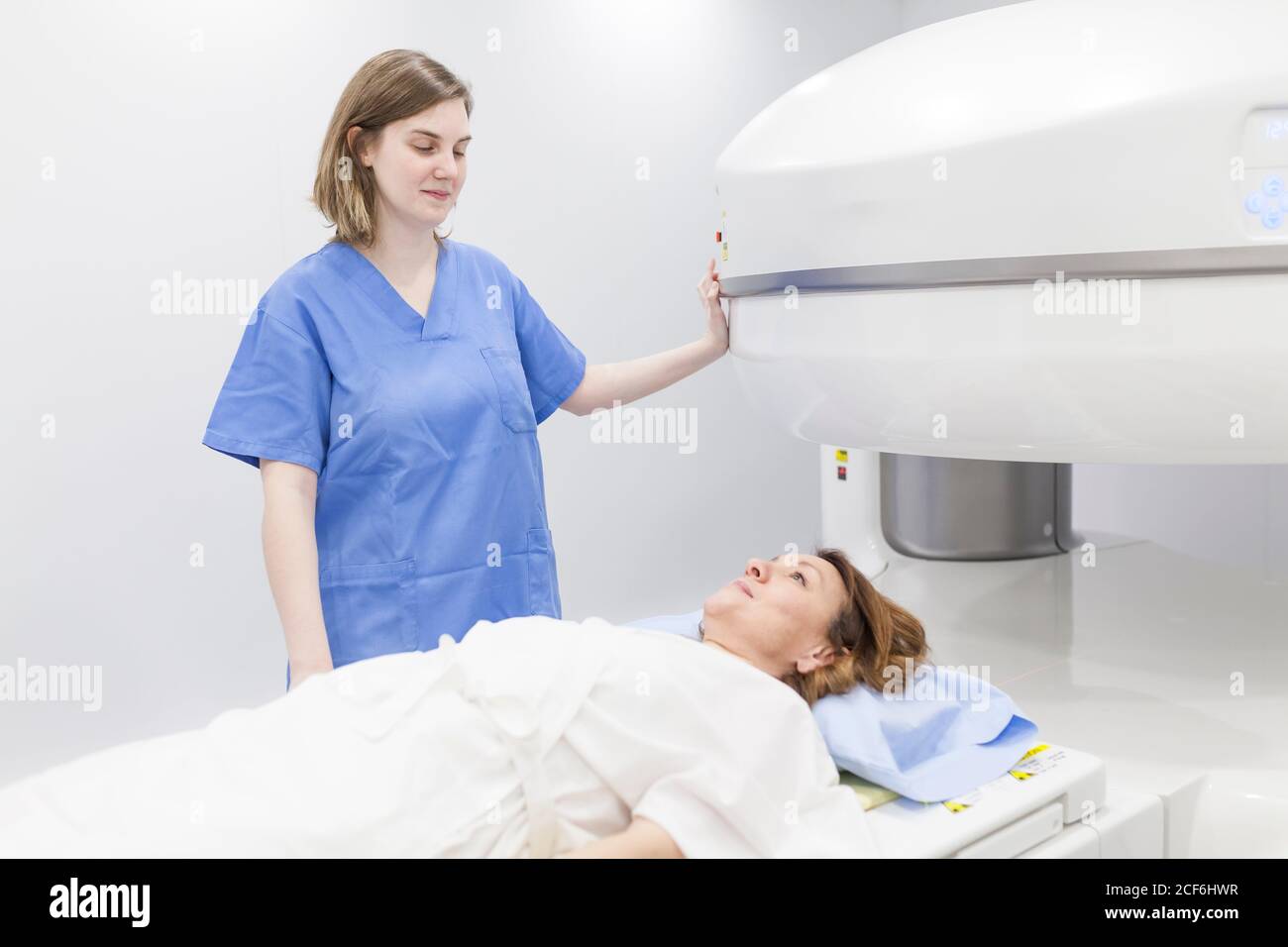 Middle-aged Woman and her doctor in an open MRI machine waiting for the ...