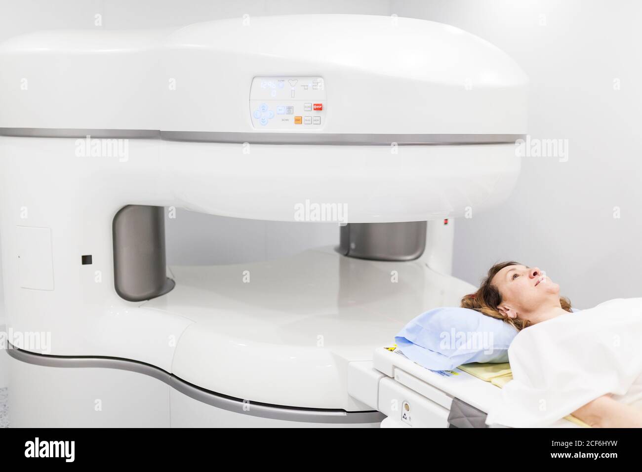 middle-aged Woman on an open MRI machine waiting for the test to begin ...