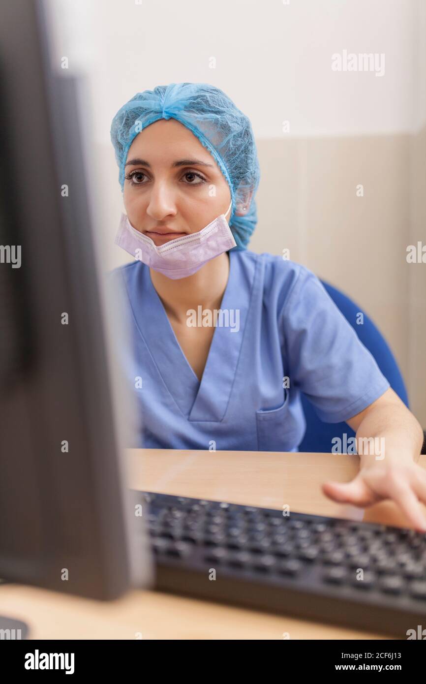 female surgeon using her computer in her office before the surgery ...