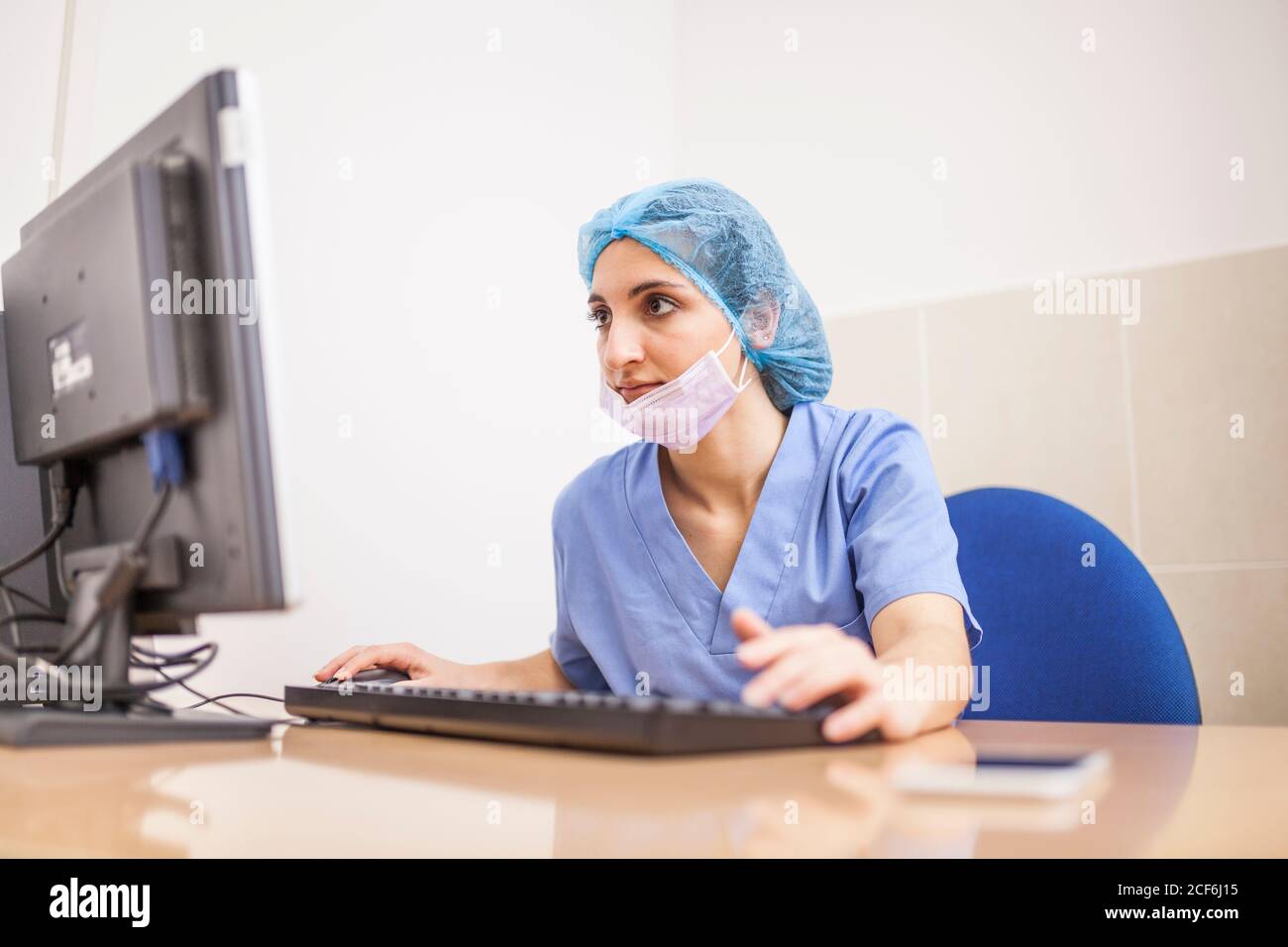 female surgeon using her computer in her office before the surgery ...