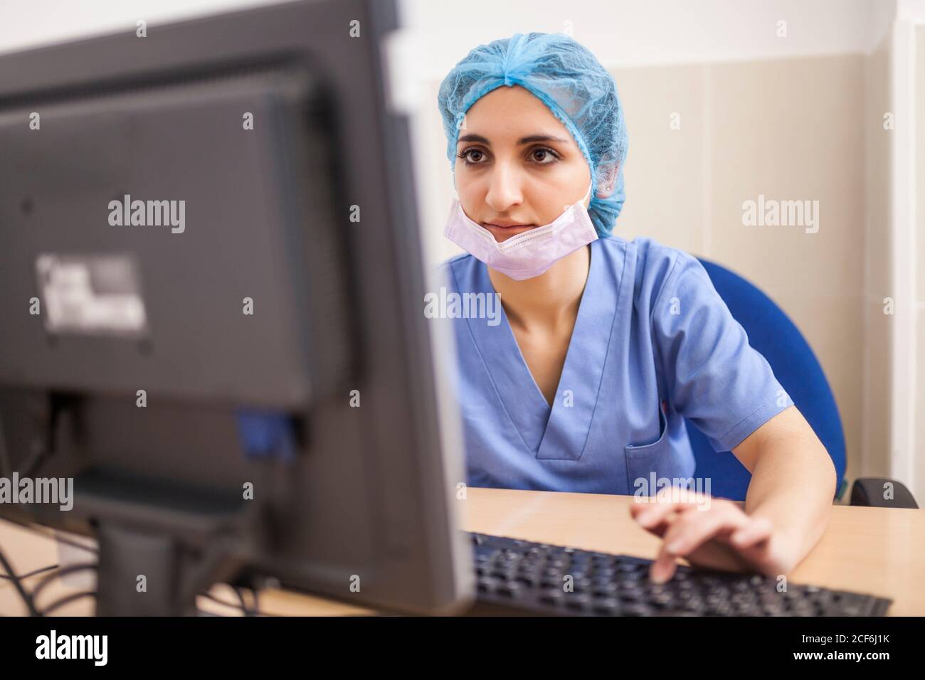 female surgeon using her computer in her office before the surgery ...