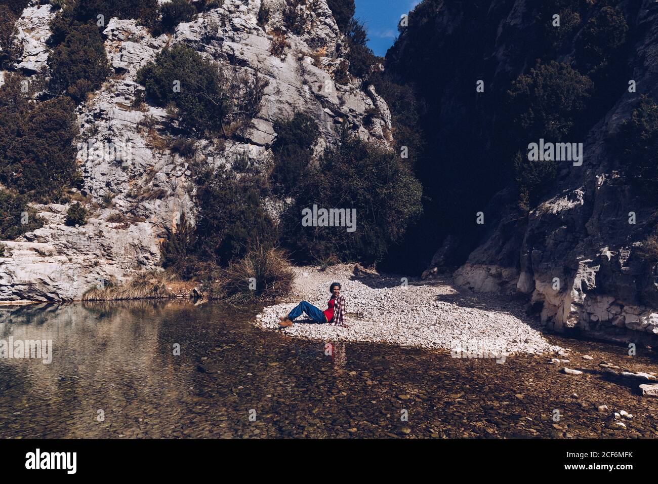 young Woman lying on rock coast of mountain river near cliff Stock ...