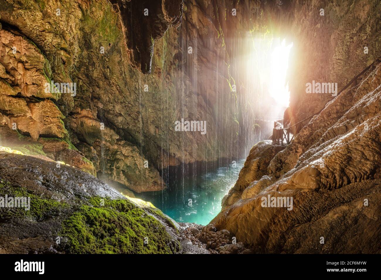Scenic tropical cave with underground river and pathway with railing in ...