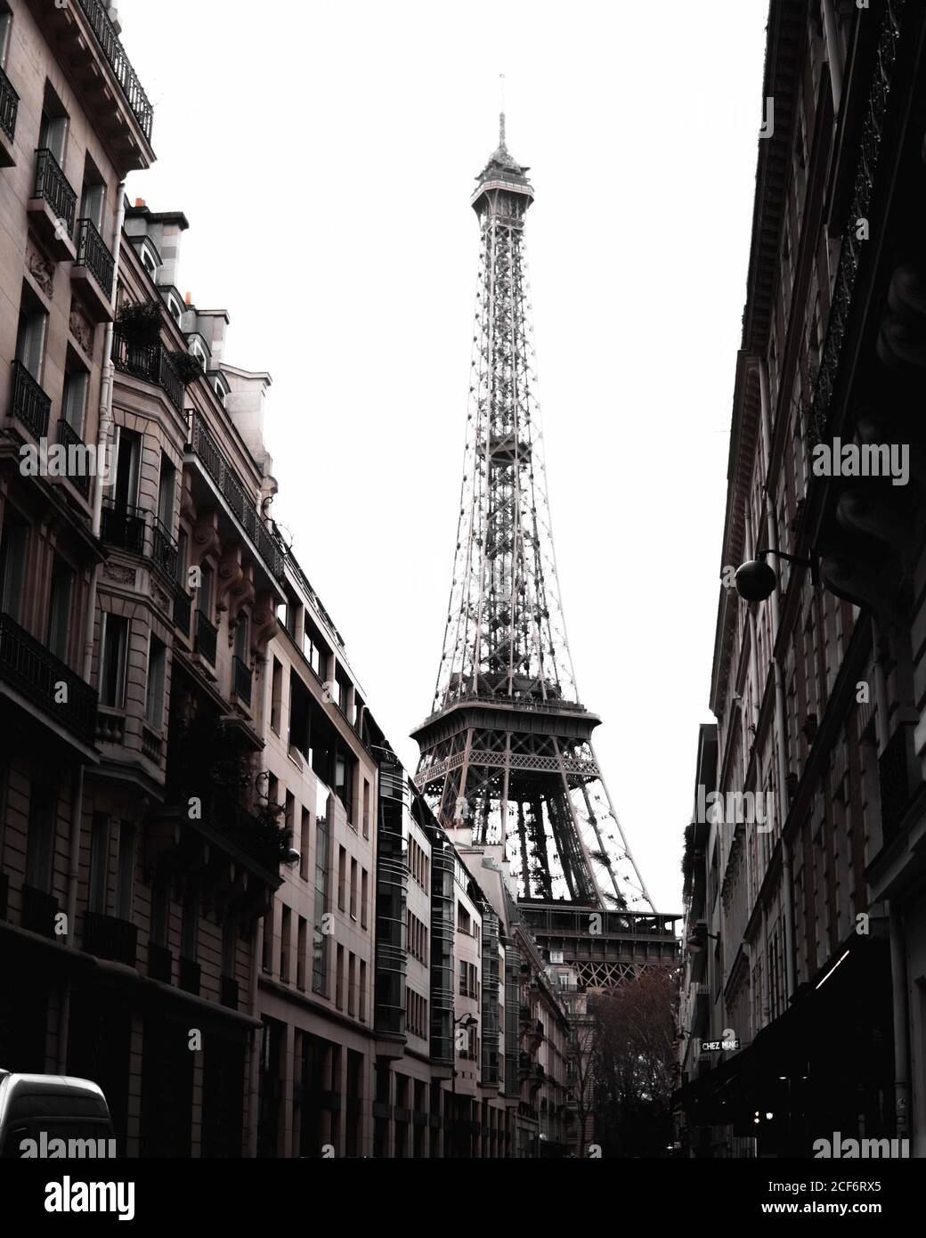 Monochrome exterior of tall stunning Eiffel Tower at end of narrow ...