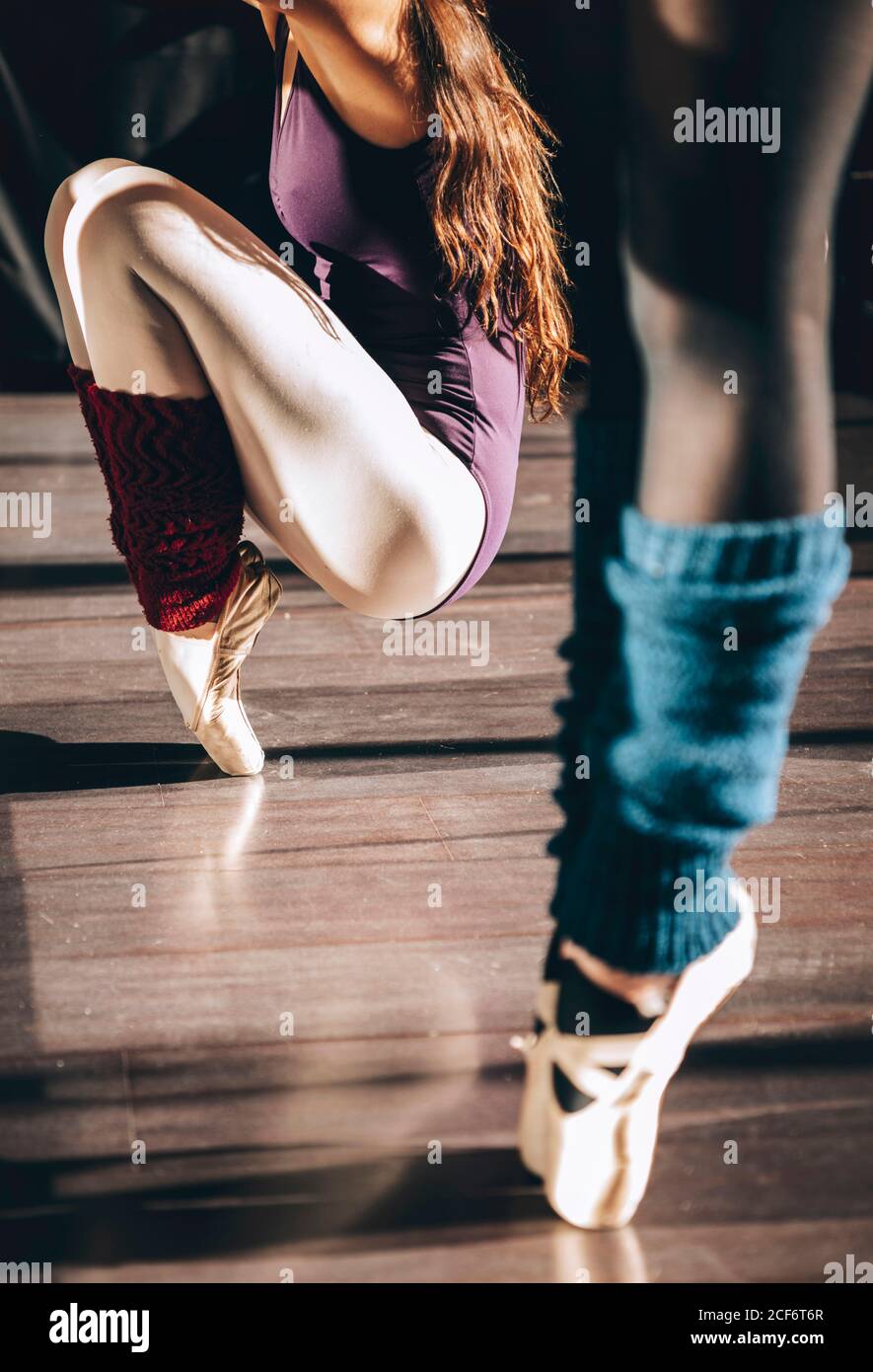 Crop shot of women training ballet in pointe shoes standing on tiptoes ...