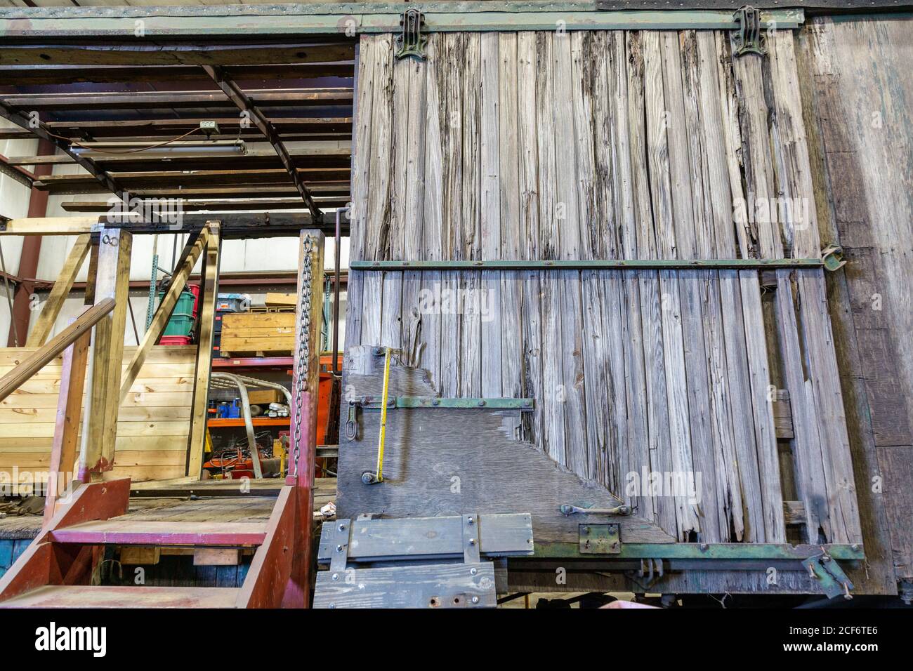 An antique wooden railway boxcar is under repair inside the Fort Wayne ...
