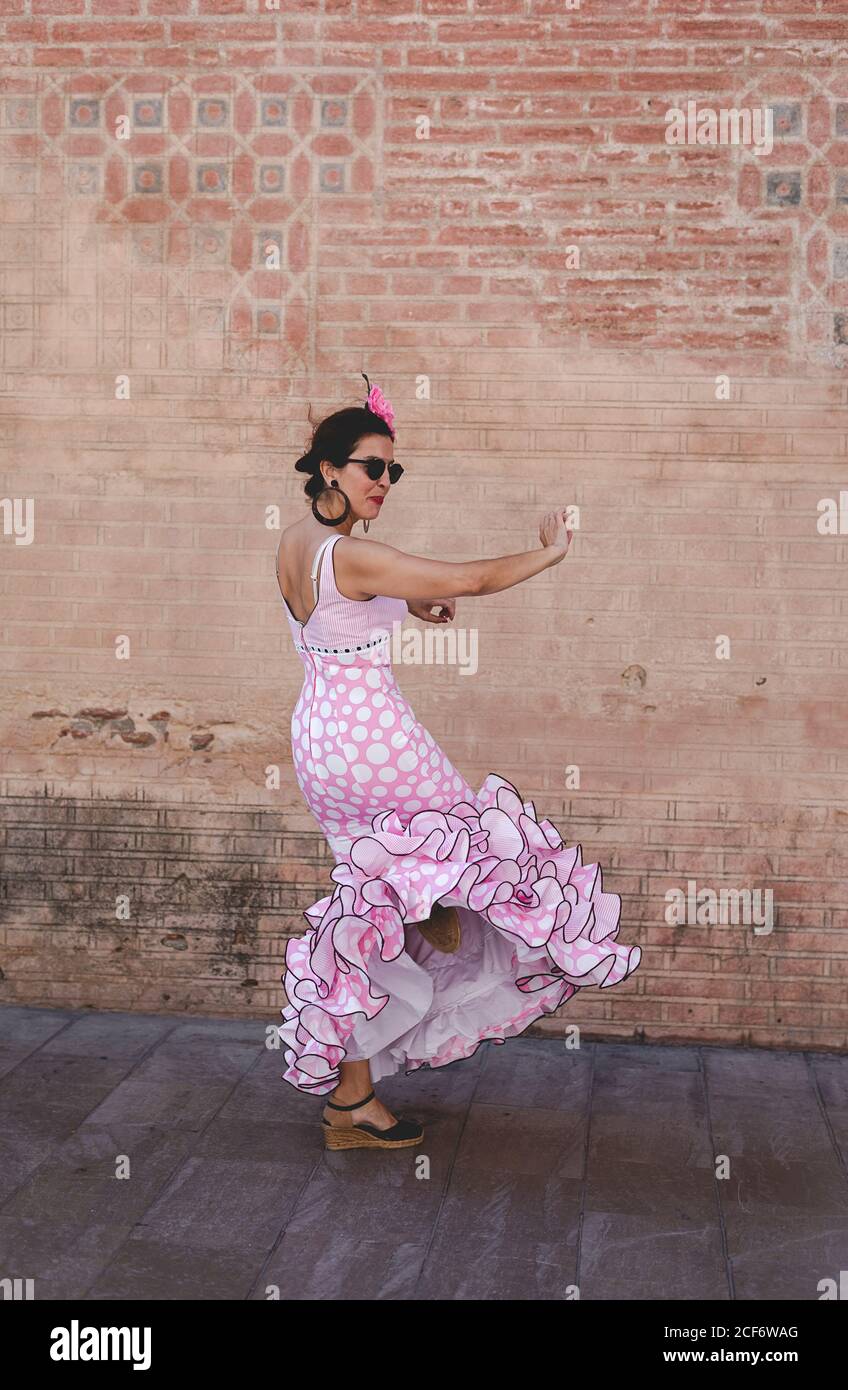 Side view of eccentric cheerful Woman in colorful pink costume smiling ...