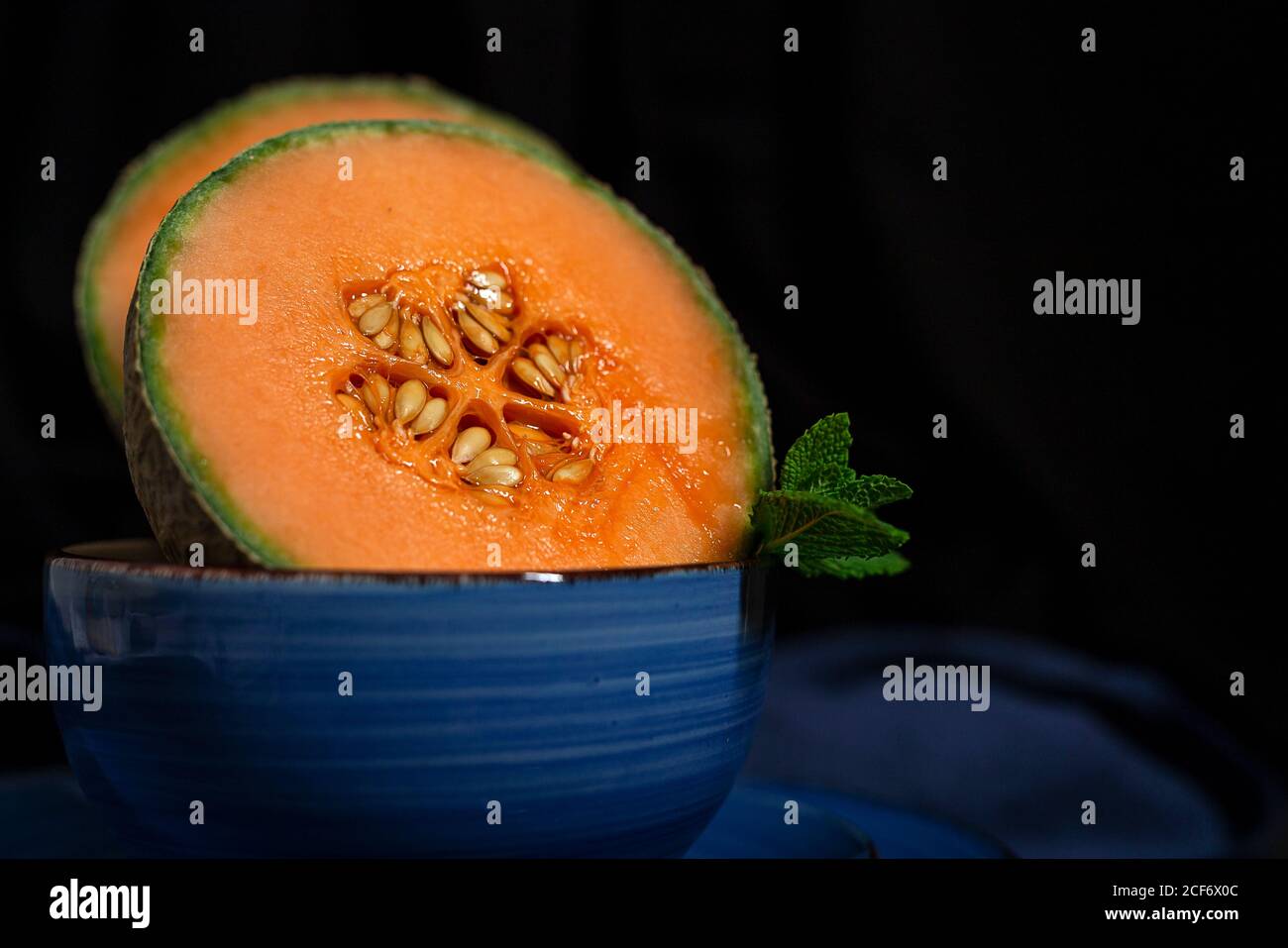Fresh assortment melon with mint on dark background. Vegan food concept ...
