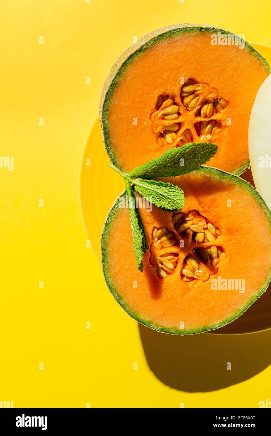 Fresh assortment melon with mint on yellow background with high ...