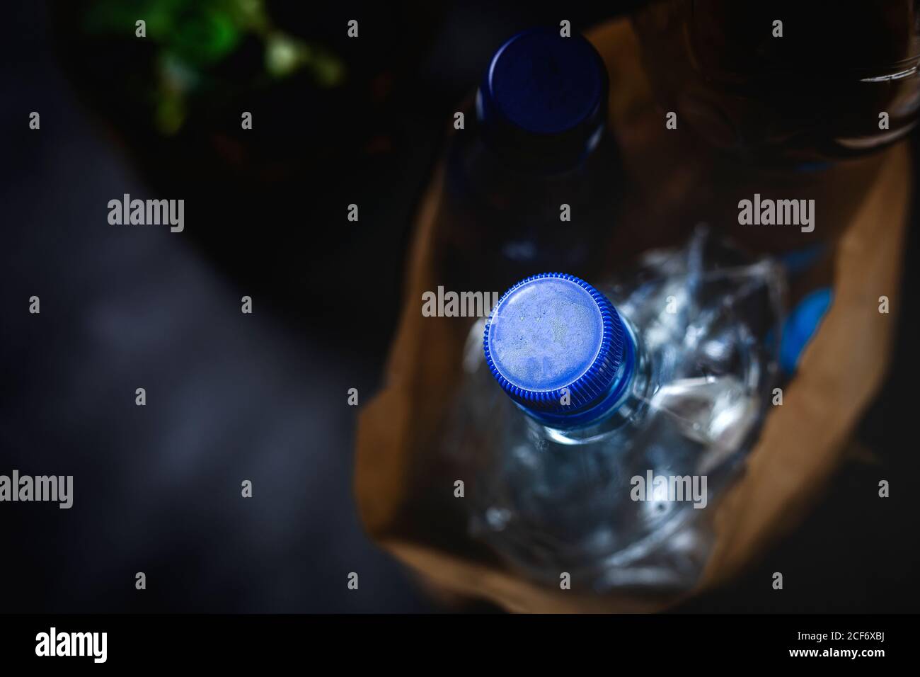 from above dirty paper sack with discarded plastic bottles placed on ...