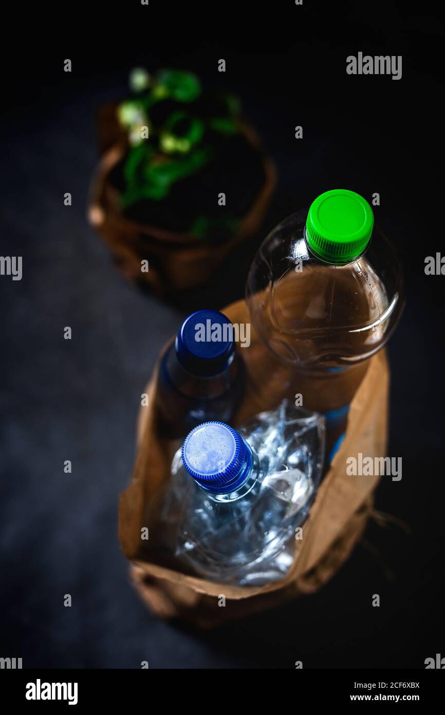 from above dirty paper sack with discarded plastic bottles placed on ...