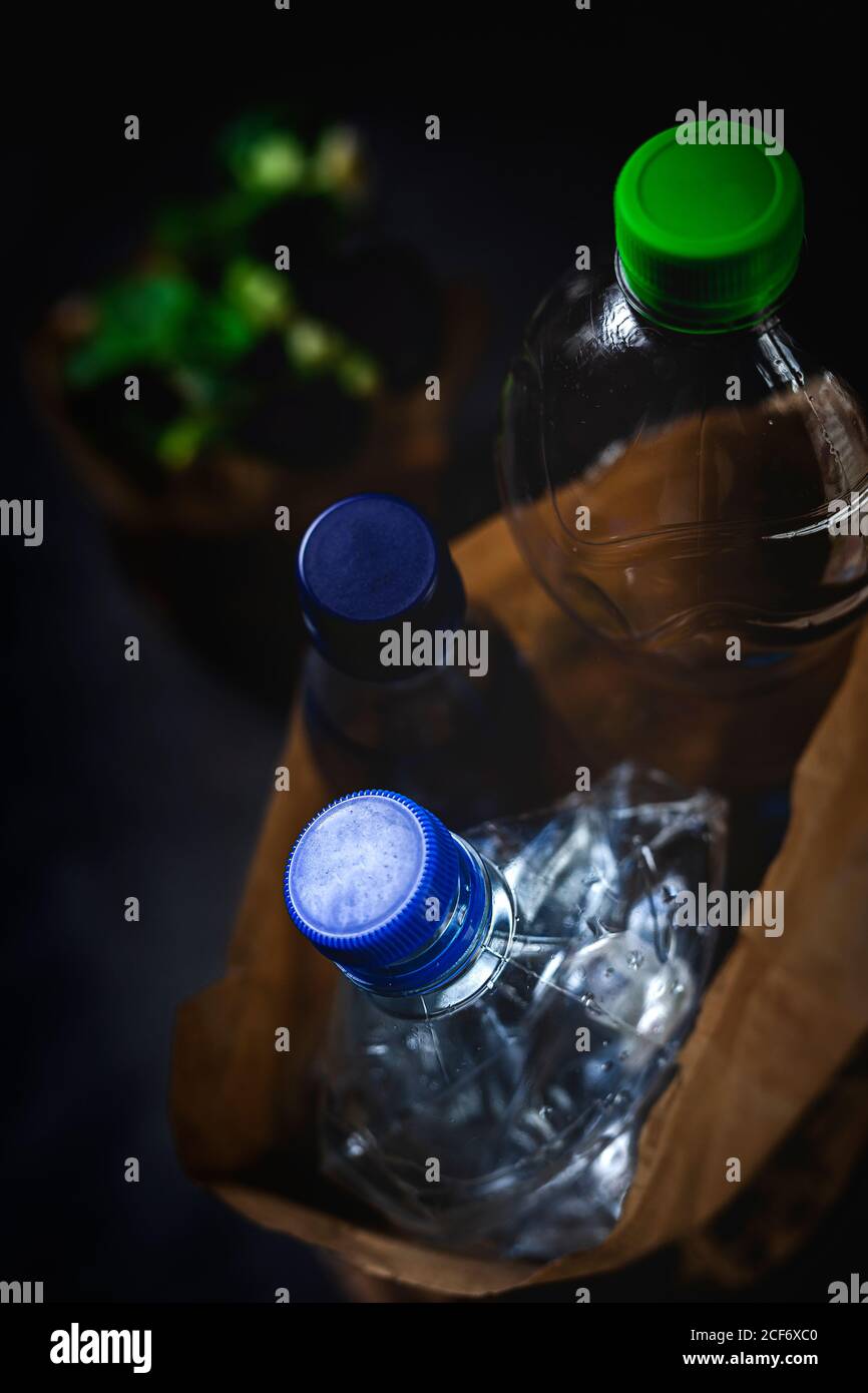 from above dirty paper sack with discarded plastic bottles placed on ...