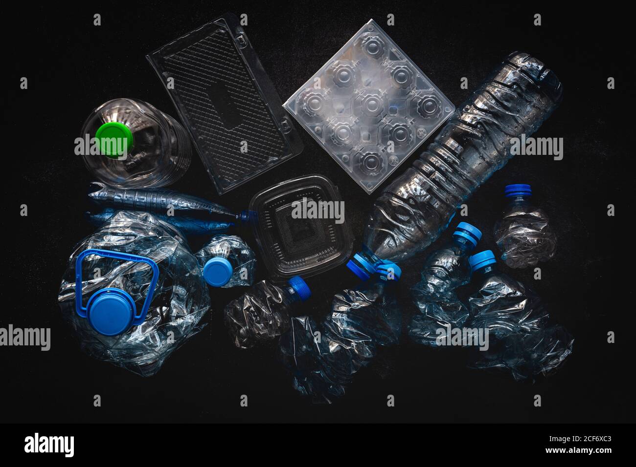 Top view of plastic bottles and boxes arranged on dark background ...